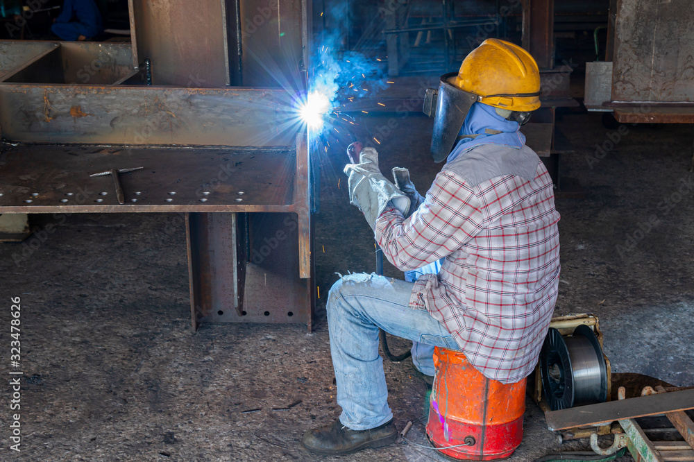 The welder is welding a steel structure work with process Flux Cored ...