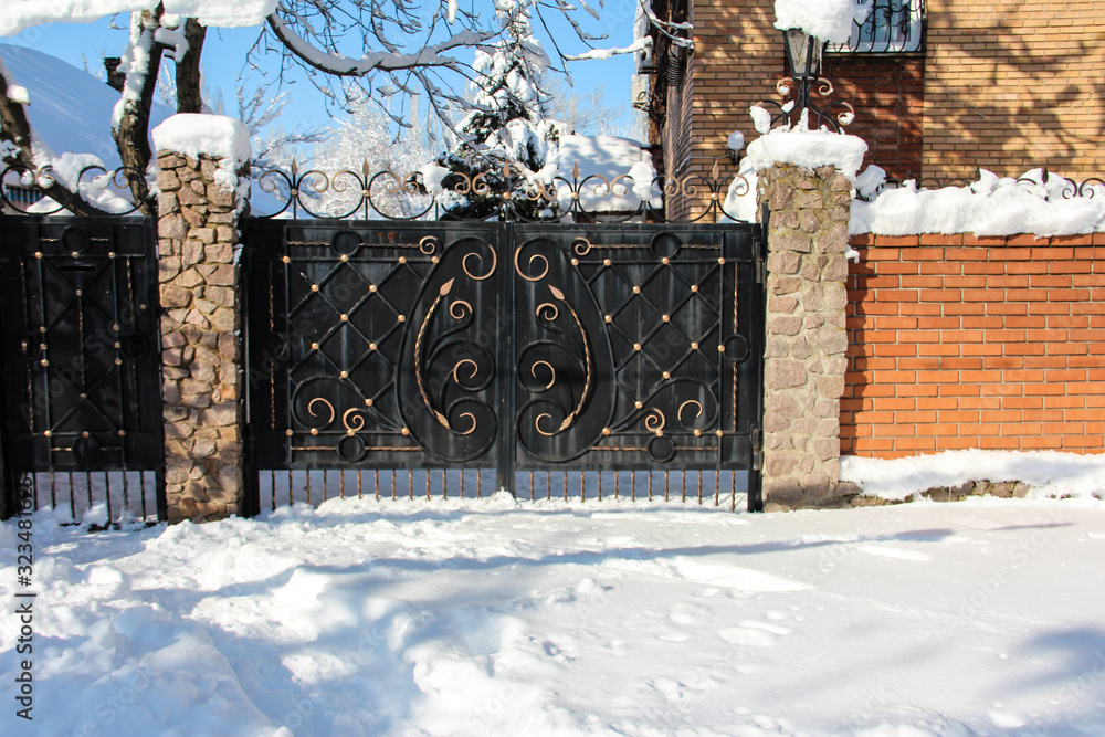 Wrought iron gates with bronze elements. Red brick fence. Stock Photo ...