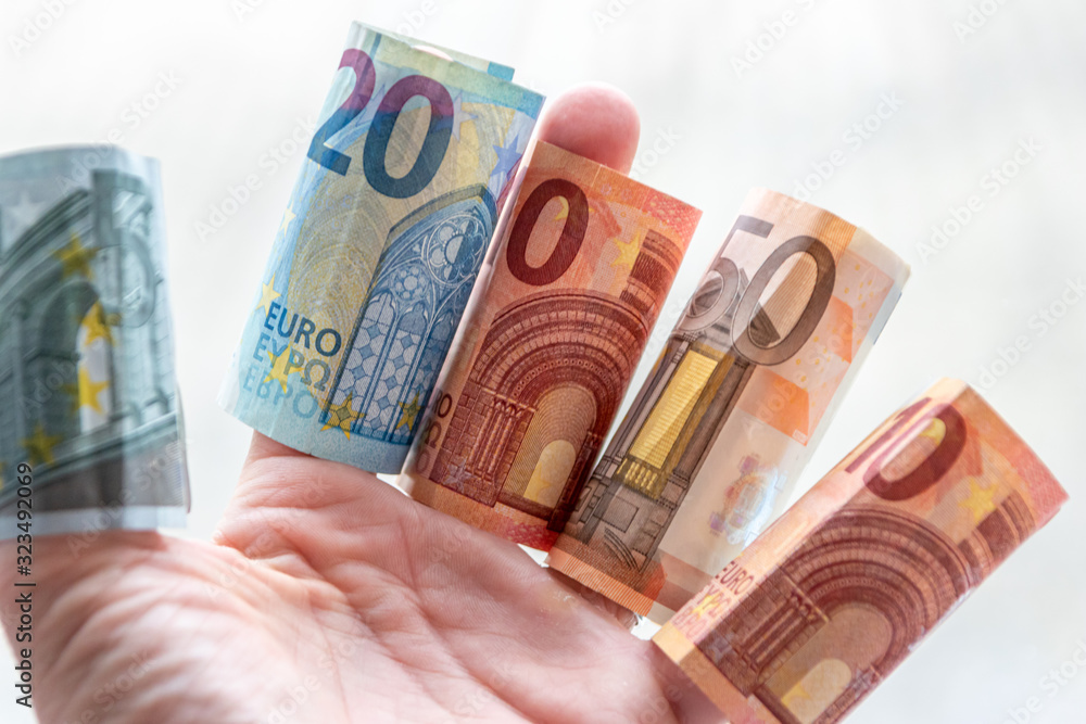 Europäische Geldscheine um die Finger einer Hand gewickelt zeigen Geld ...