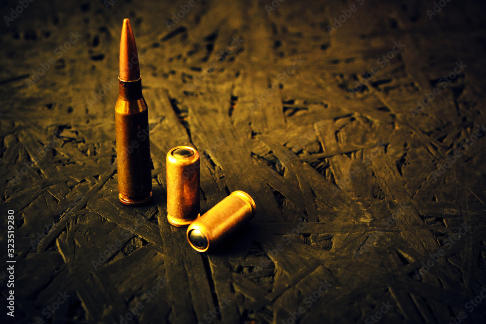 Bullets from a machine gun and a pistol on a dark background. Stock ...