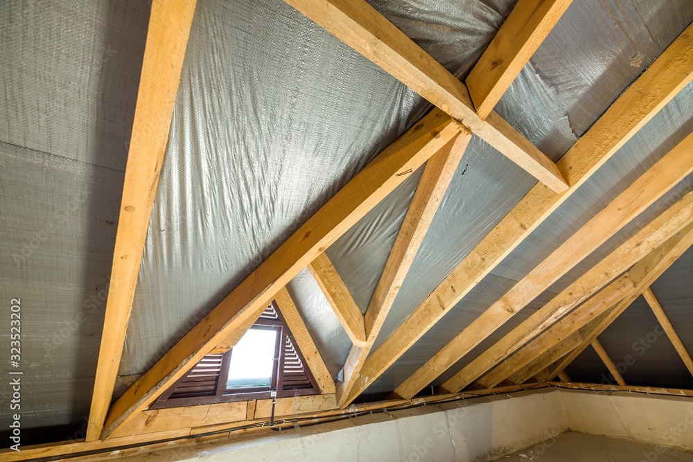 Attic of a building with wooden beams of a roof structure and a small ...