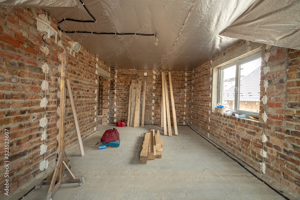 Interior of unfinished brick house with concrete floor and bare walls ...