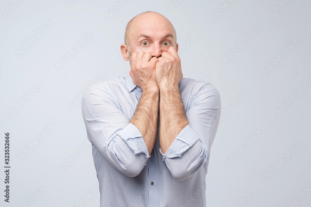 Scared mature man covering mouth. Studio shot. Male saw a ghost. Studio ...