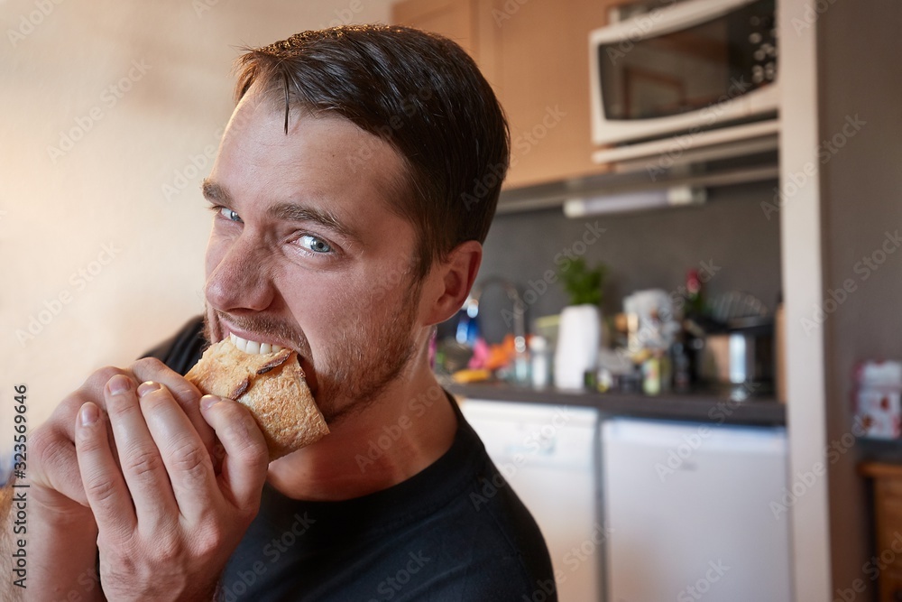 Eating a sandwich biting with enthusiastic expression Stock Photo ...