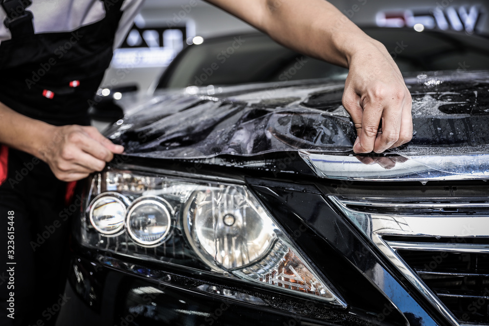 Close up of paint protection film installation on front bumper of ...