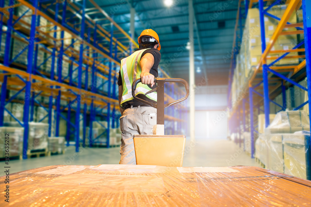 Warehouse worker unloading pallet shipment goods, Interior of storage ...