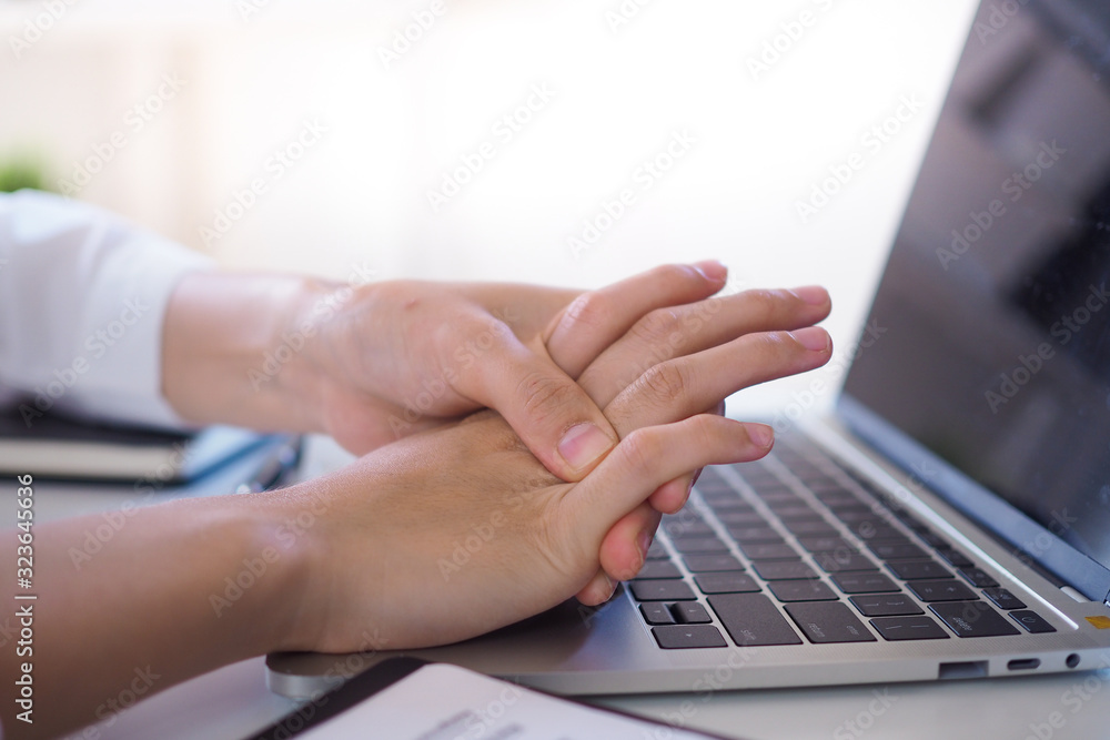 Business woman pressing the middle of her palm with her thumb to ...