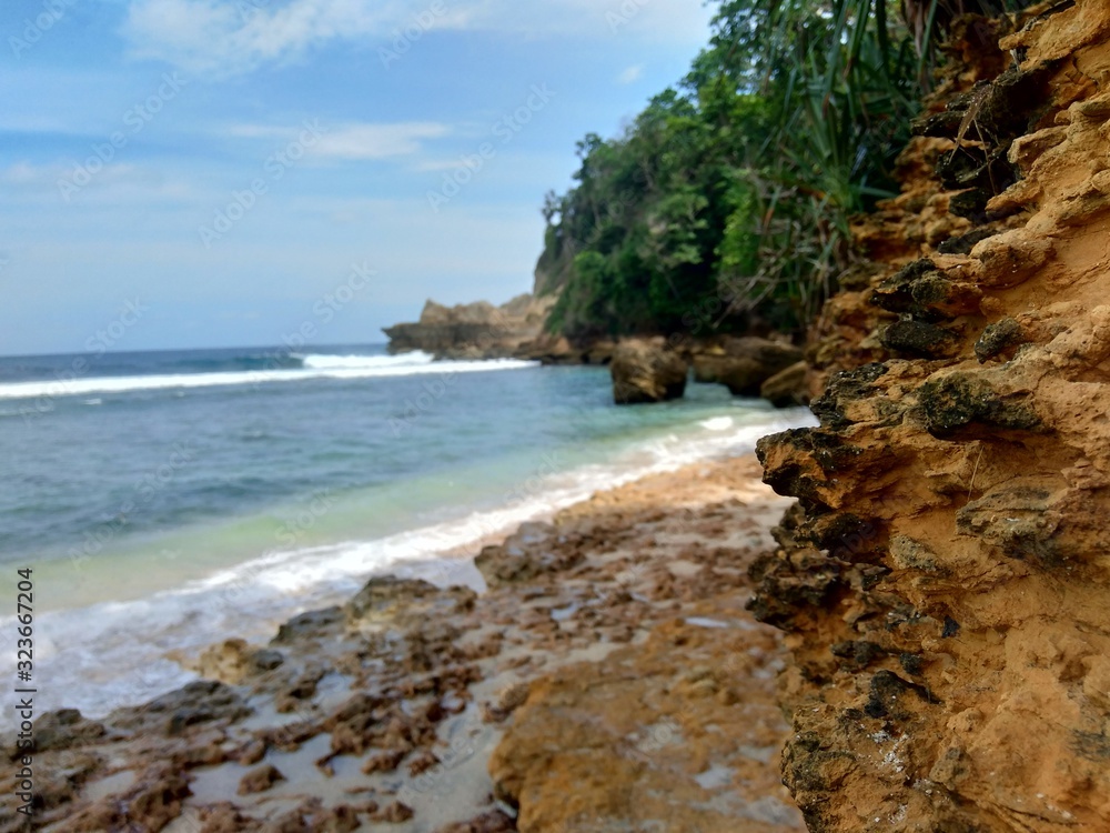 Beach with rocks, waves and blue sky. The beautiful Sanggar beach in ...