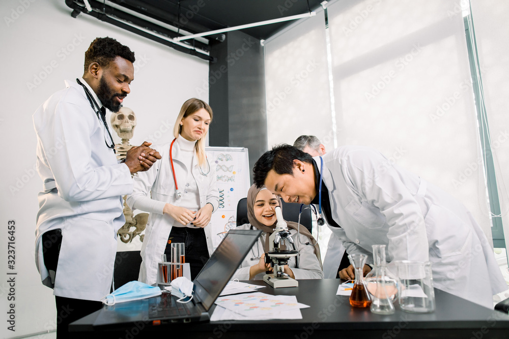 Group of multiethnic scientists feel happy after successful trial ...