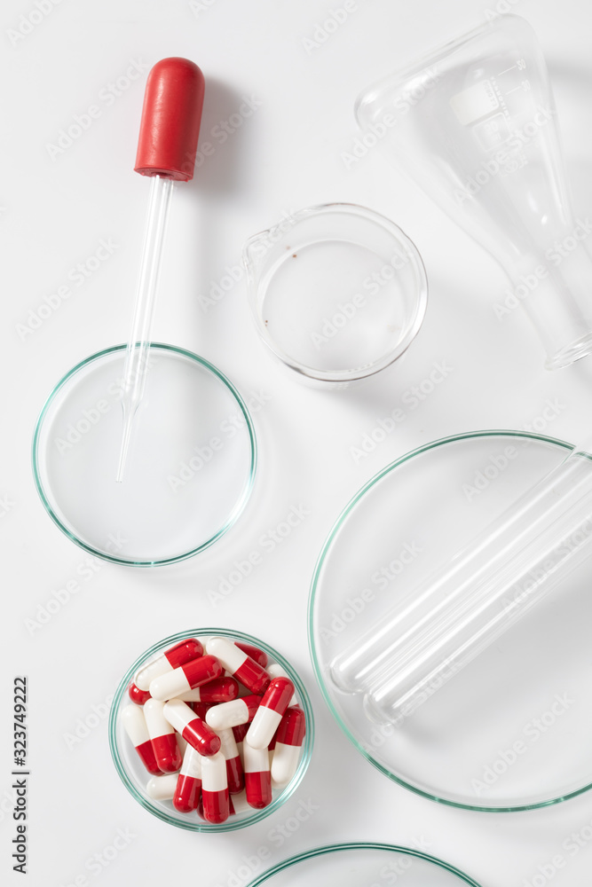 medicine capsule with laboratory equipment on white background for ...