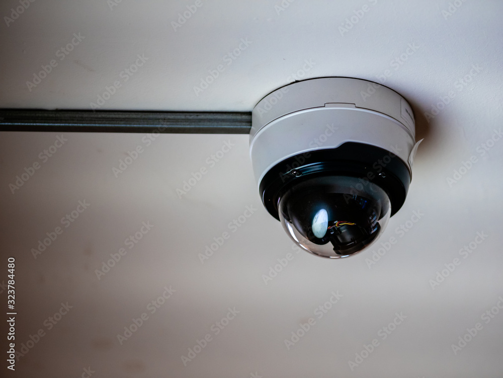 Dome surveillance camera in a transparent hemisphere. CCTV video camera ...