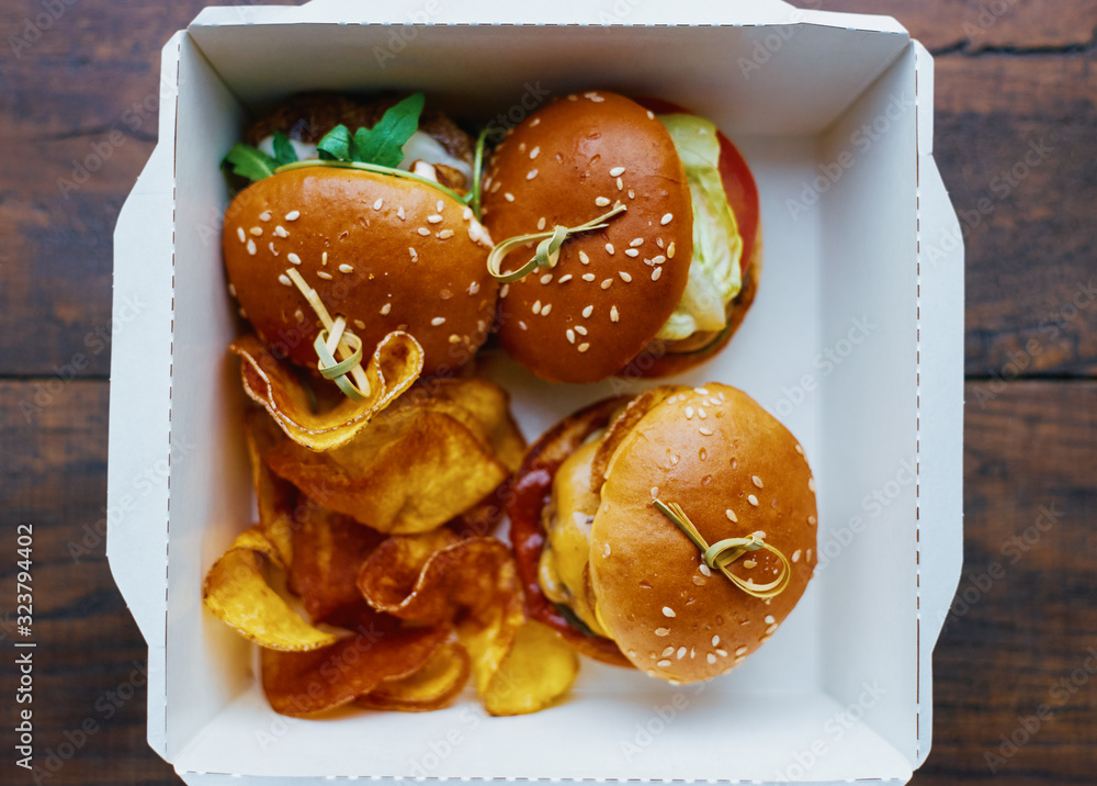 Box with three different mini burgers and chips unhealthy food Stock ...
