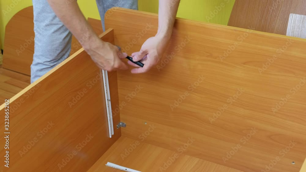 Man collecting parts of table joining them together. Man is collecting ...