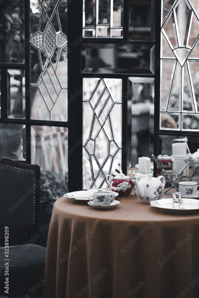 The interior of a cozy cafe in an old style. Stained glass windows ...