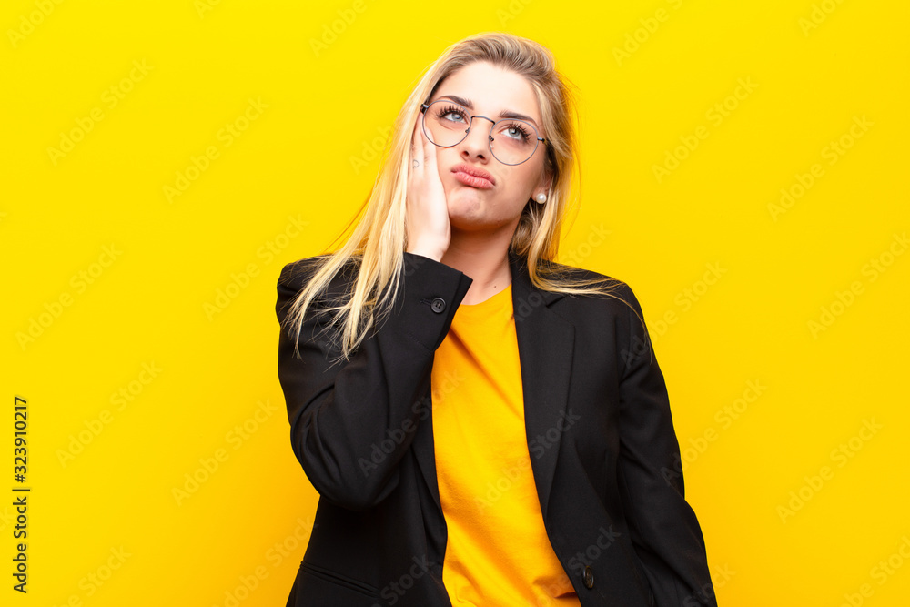 young pretty blonde woman feeling shocked and astonished holding face ...