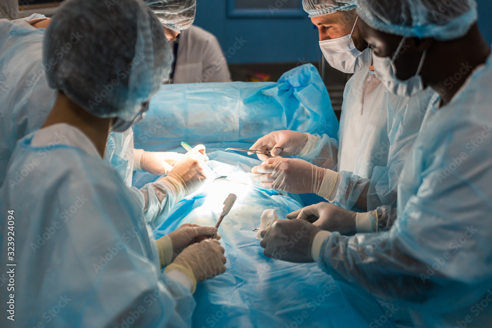 An international team of doctors performs a complex surgical operation ...