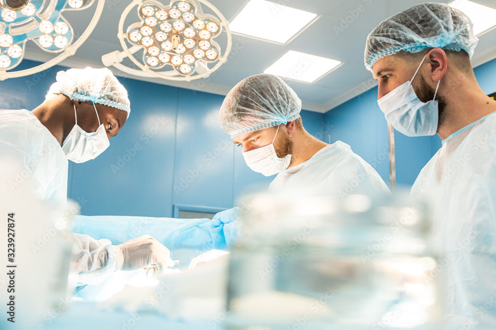 An international team of doctors performs a complex surgical operation ...