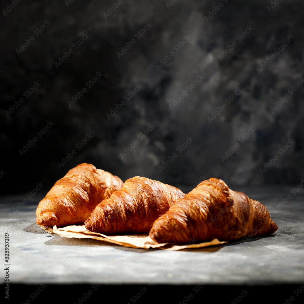 Fresh croissant on dark mood background and copy space for your product ...