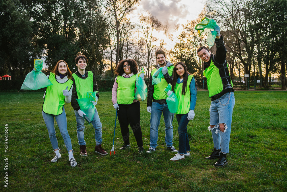 Group of friends during a volunteer garbage collection event in a park ...