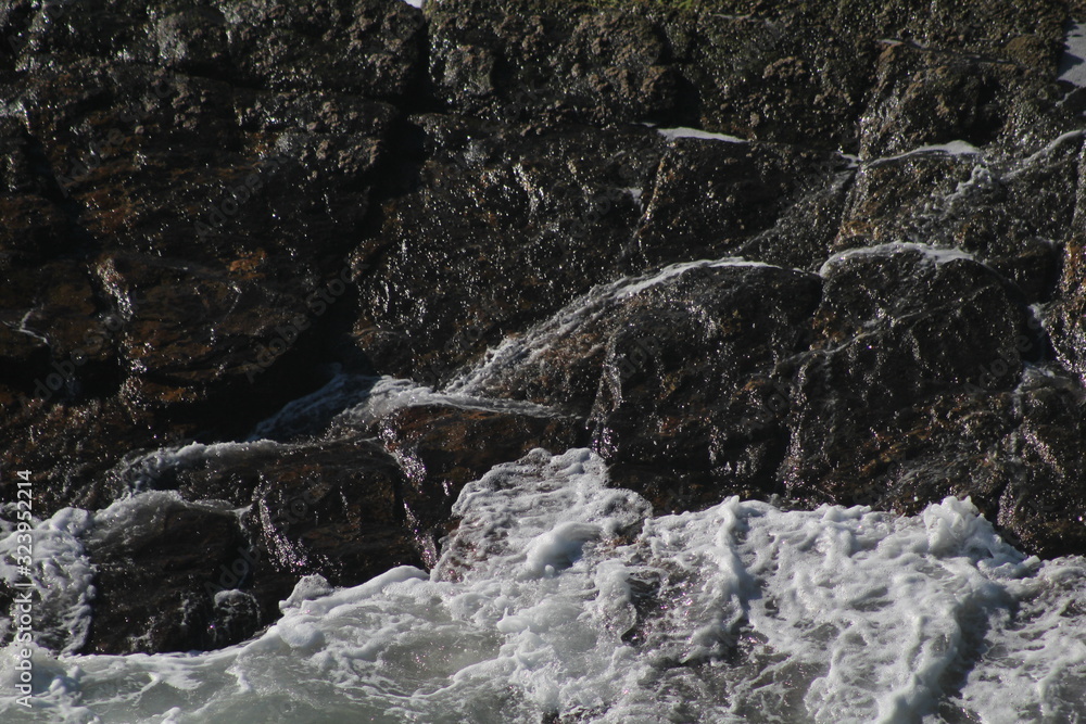 Textura de agua de mar sobre rocas con luz directa del sol en la playa ...