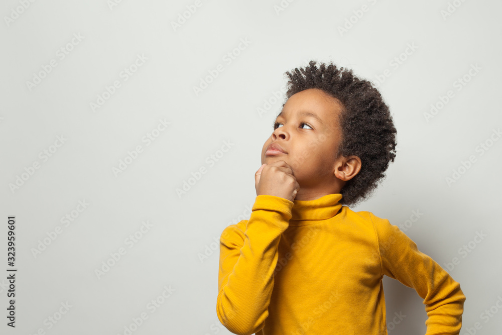 Smart schoolboy black kid boy thinking on white background фотография Stock | Adobe Stock