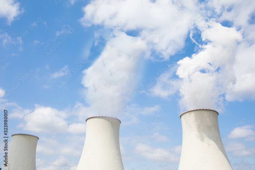 Power plants in the blue sky white clouds the sky background. Tops of ...