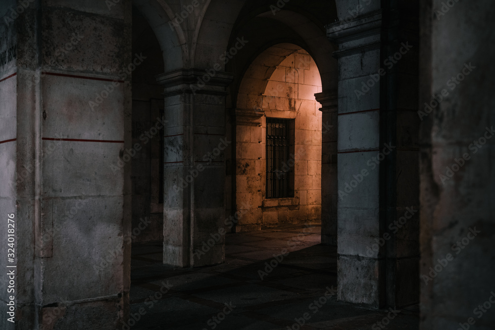 Old fashioned lantern illuminating shabby arches of ancient cathedral ...