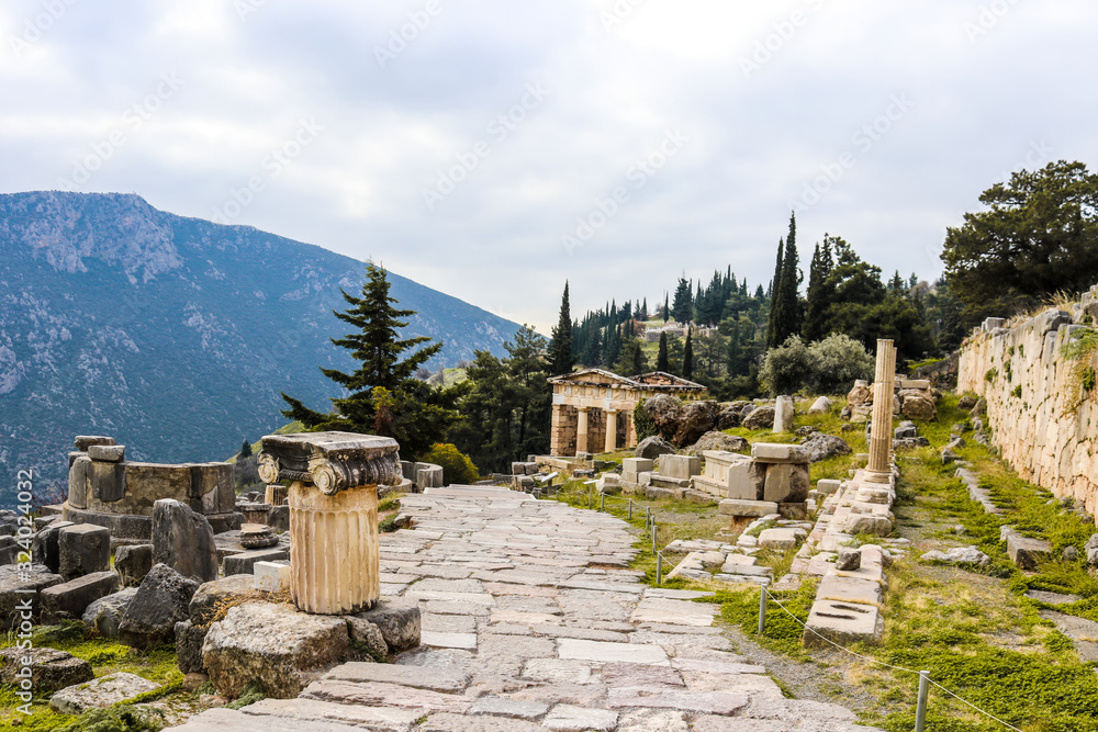 Rock walkway down hill in ancient Delphi Greece past ionic columns and ...