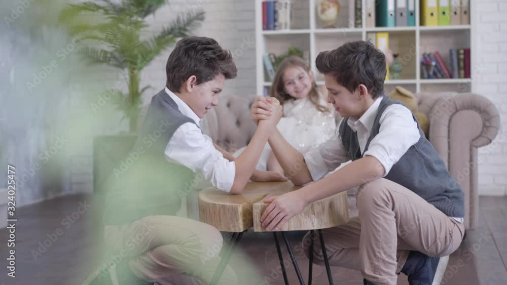 Video Stock Two identical twin brothers competing in armwrestling and ...