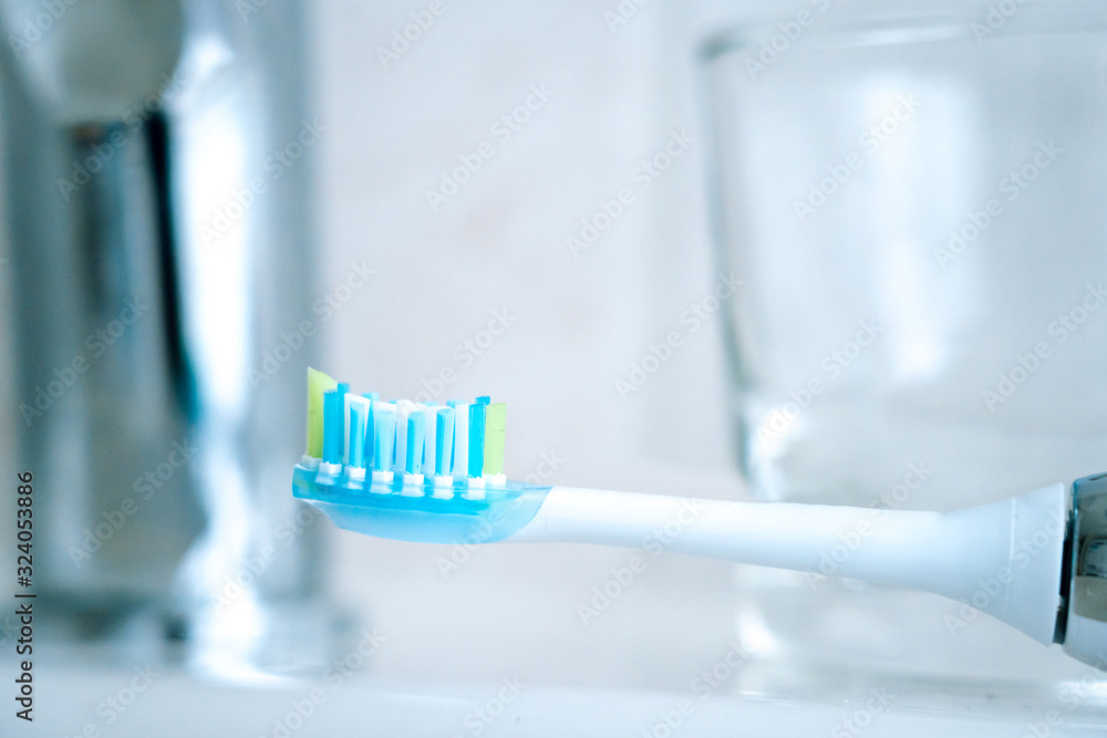 Pink electric toothbrushes and glass in the bathroom at home ...