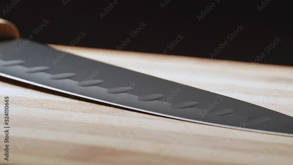 Kitchen knife laying on wooden desk, close shot. Camera moving from ...