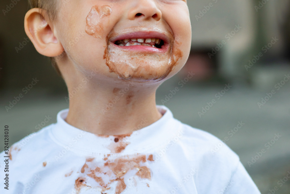 Cute boy with chocolate ice cream on face. Kid with a dirty face after ...