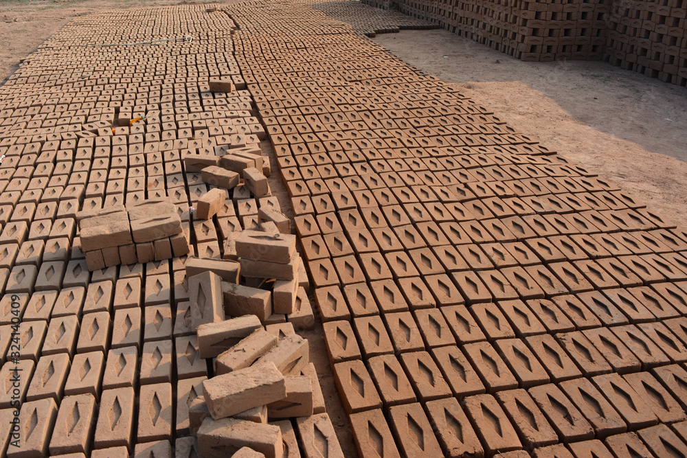 Raw brick laid out in stacks for drying. Bricks in a brick factory ...