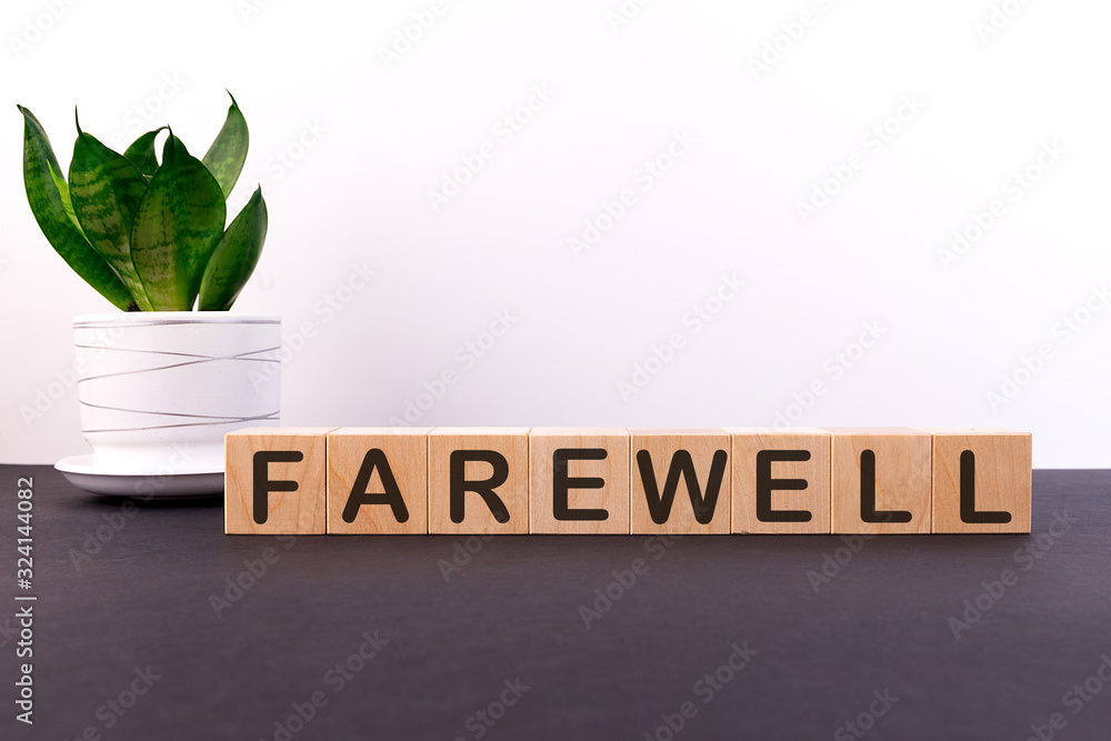 FAREWELL word concept written on wooden blocks, cubes on a dark table ...