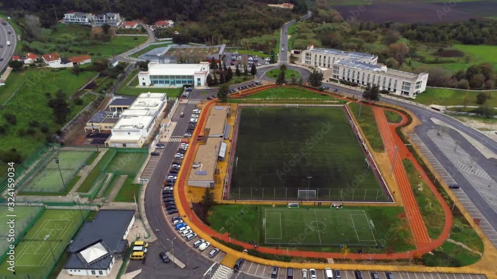 Zoom in aerial view of an open air Soccer compound including a full ...