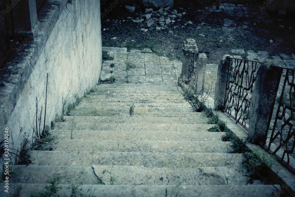 Abandoned stone stairs, with grass filling the cracks, and a broken ...