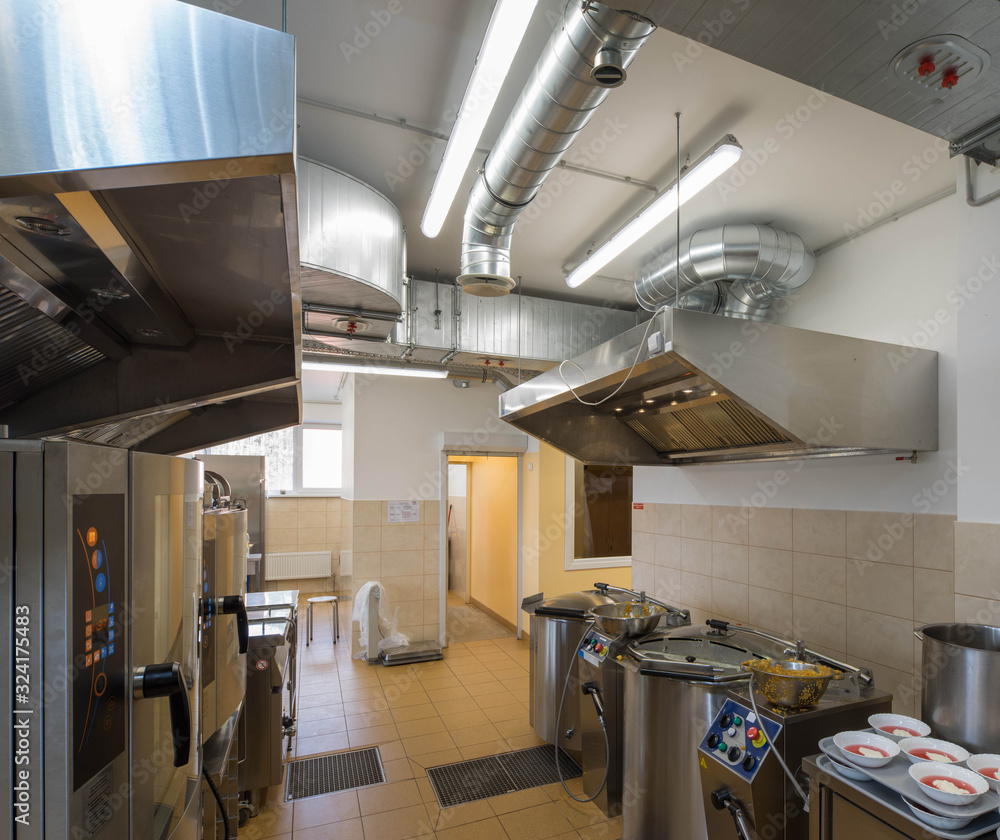 Interior of restaurant kitchen. Metal piping ventilation system ...