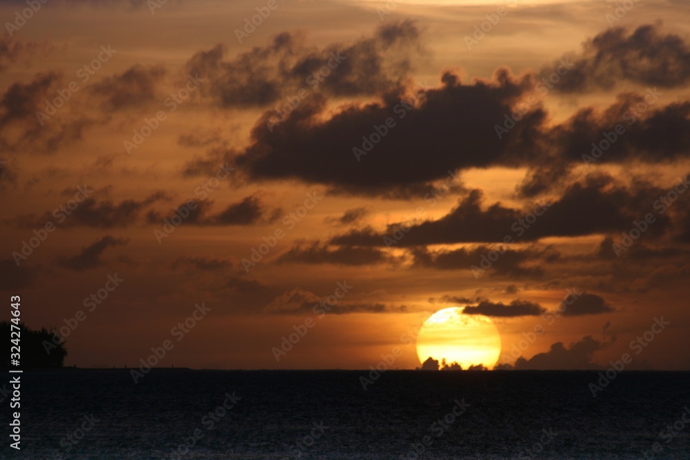 Foto de Amazing view of a huge round sun starting to set in the horizon ...