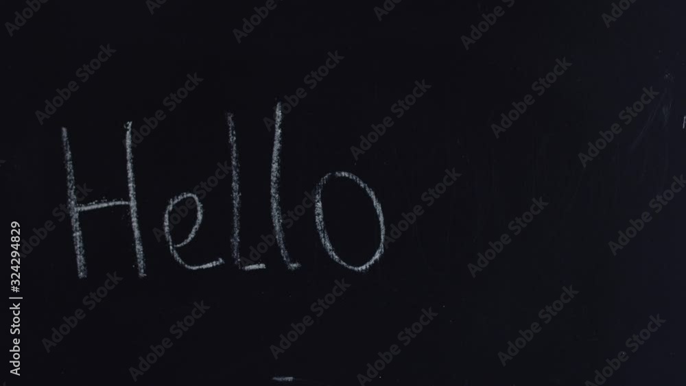 The word Hello is chalked on the blackboard. A man's hand writes the ...