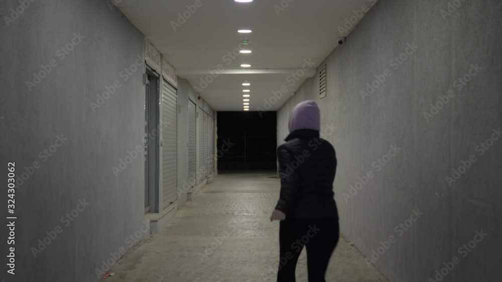 Stockvideo Frightened girl in a hoodie is running away from her pursuer ...
