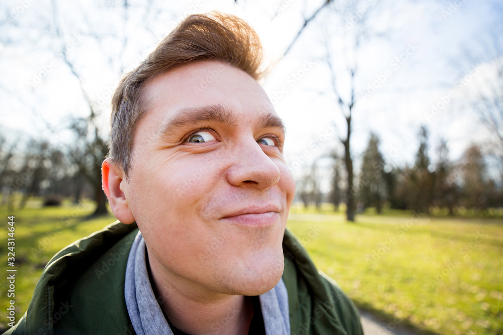 Portrait of a young man on nature background. Emotion facial expression ...