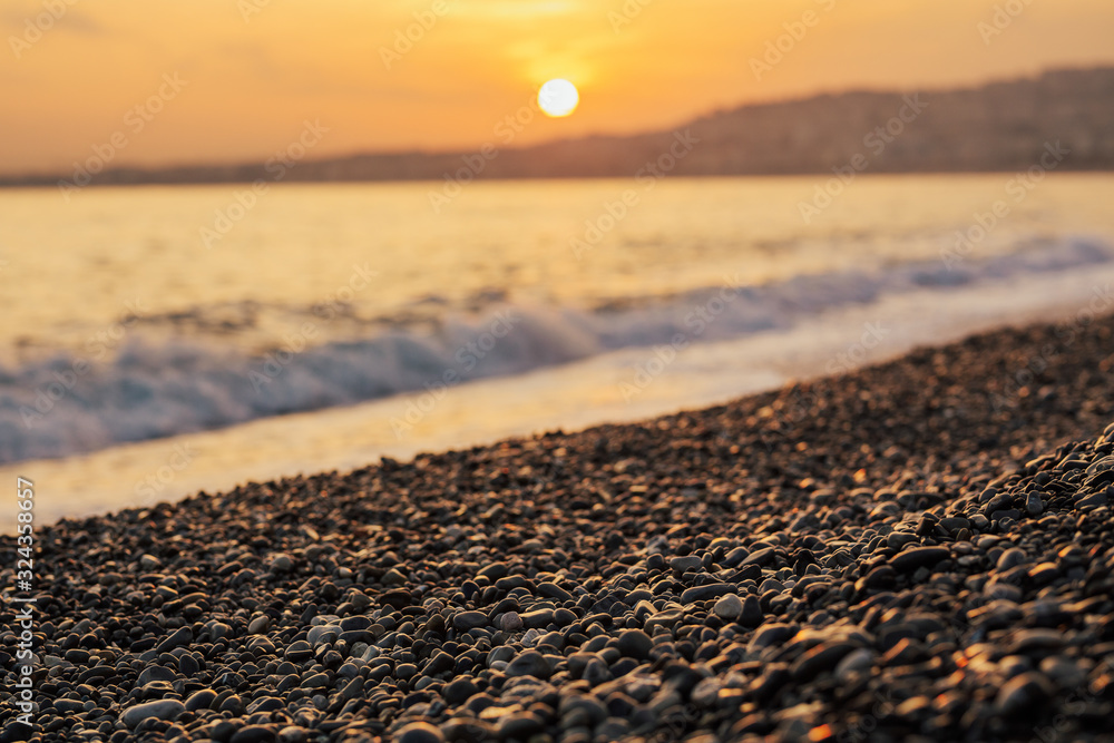 Pebble beach in Nice,France during beautiful orange sunset. The sunset ...