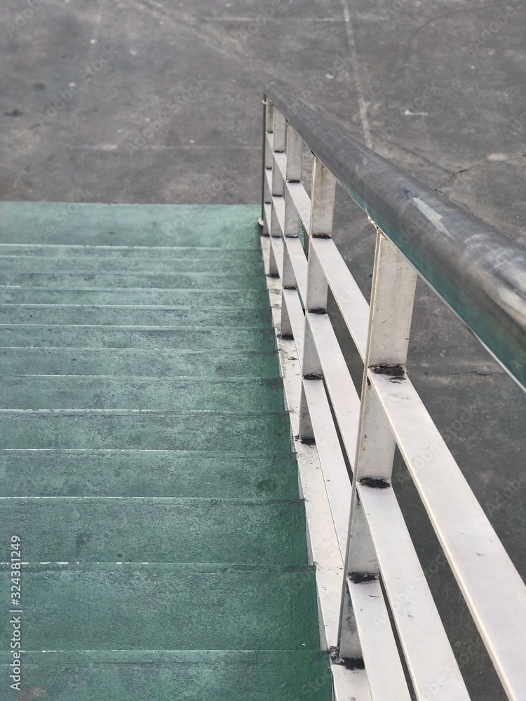 The green steps of elevated pedestrian overpass with the aluminium bars ...