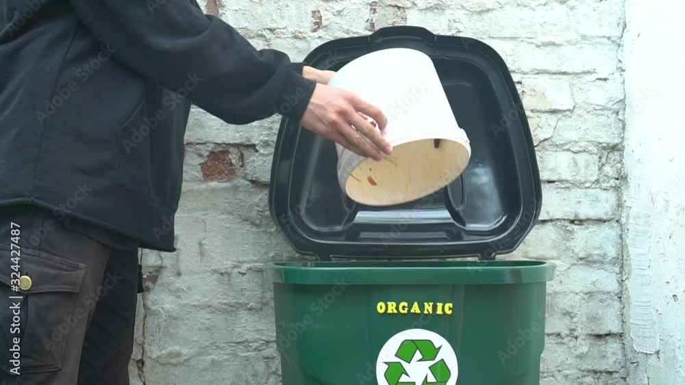 Organic bin with recycling symbol. Adding organic materials, grass ...