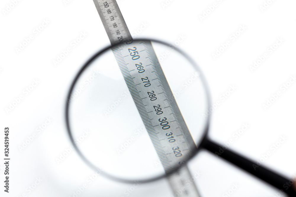 Metal ruler isolated on white background, zoomed image with magnifying ...