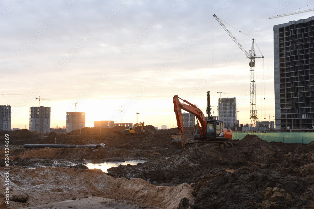 Large tracked excavator at construction site on the background sunset ...