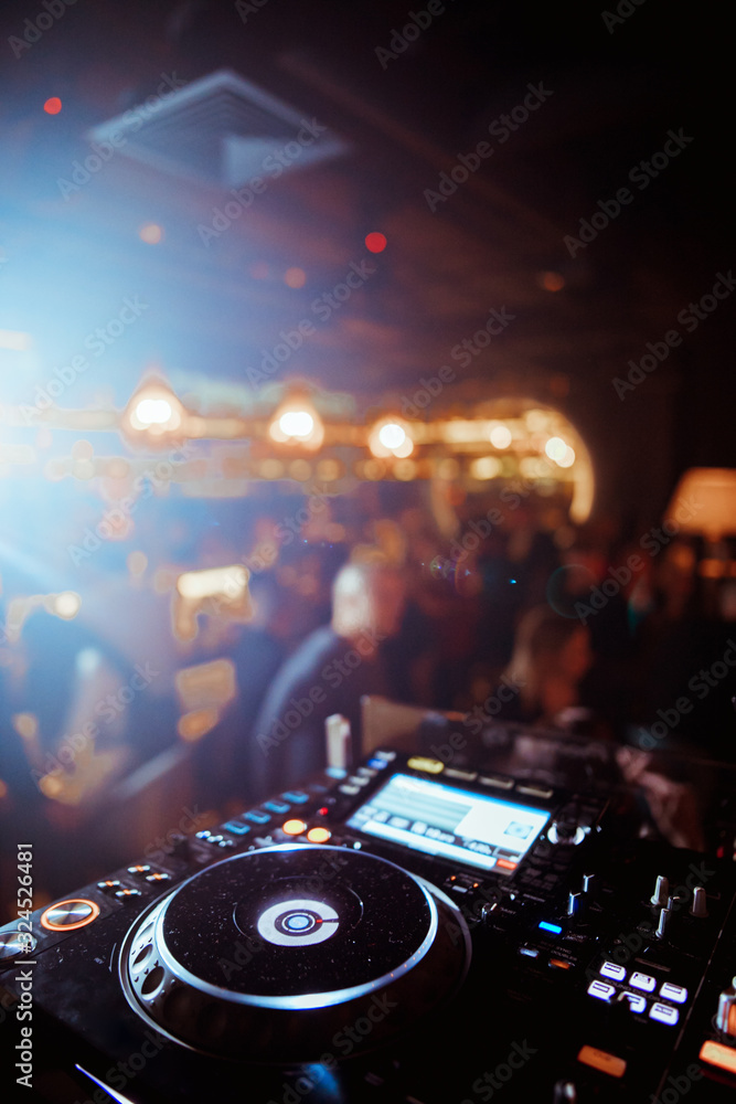 Club DJ playing mixing music on vinyl turntable at party wearing ...