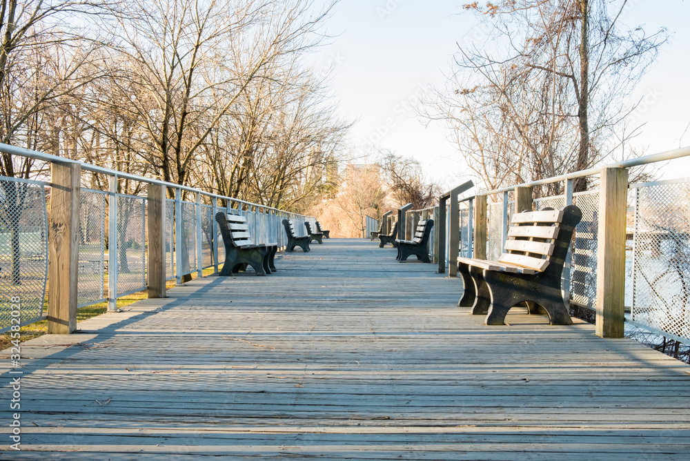 Outdoor wooden walkway with park benches. Outdoor sitting area with ...
