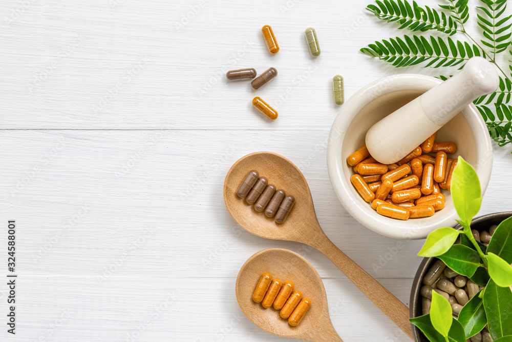 Herbal supplement in capsules with healthy medicinal plant.Alternative ...