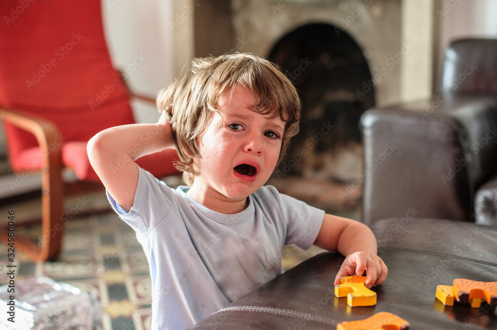 child cries with tears on his face while playing at home Stock Photo ...
